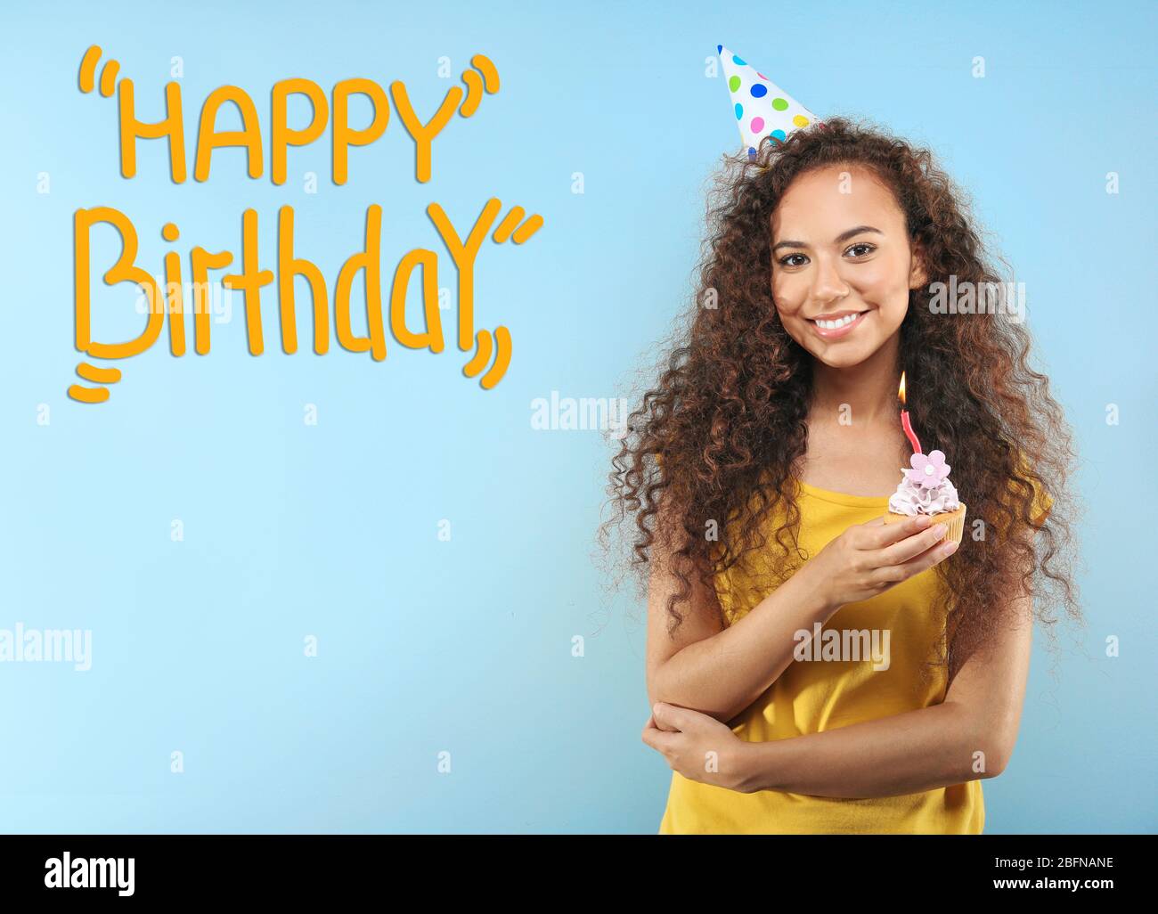 Beautiful African-American girl with birthday cupcake on blue ...