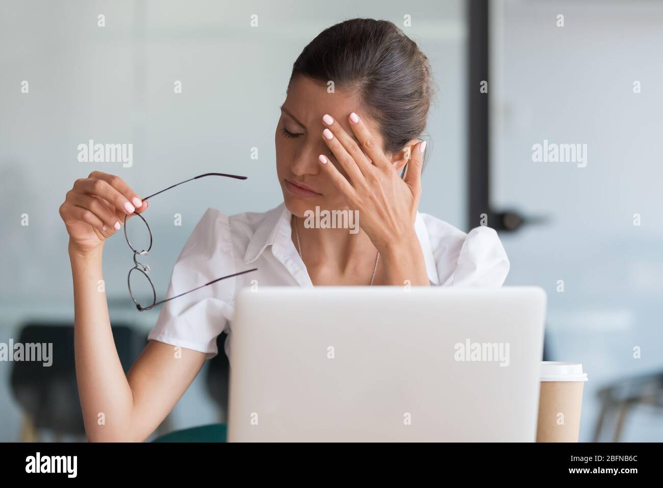 Millennial woman taking off glasses tired of computer work Stock Photo ...