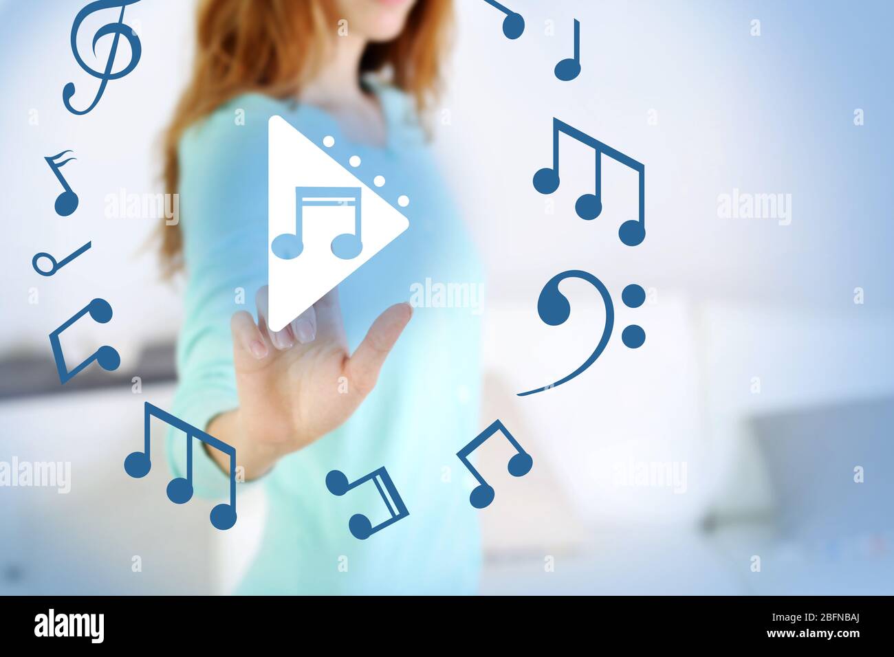 Woman pushing PLAY button on virtual screen to launch music player ...
