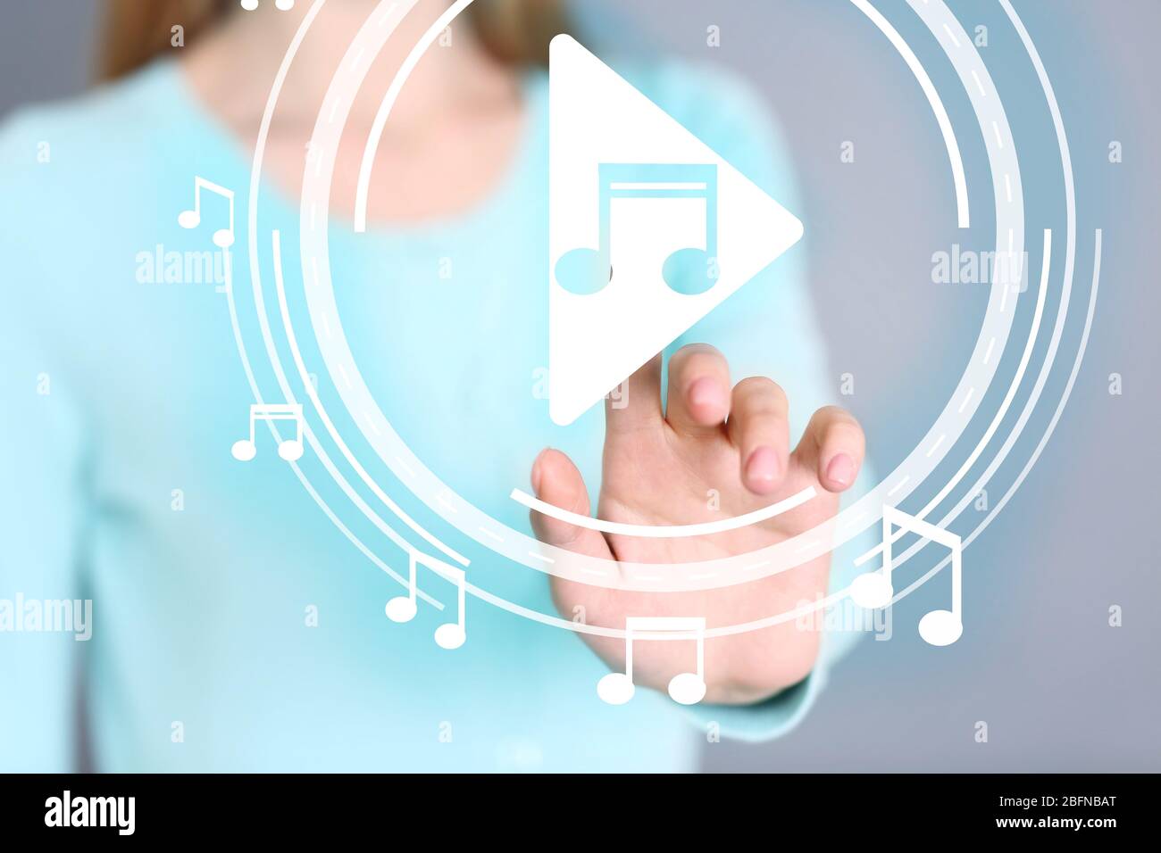 Woman pushing PLAY button on virtual screen to launch music player ...