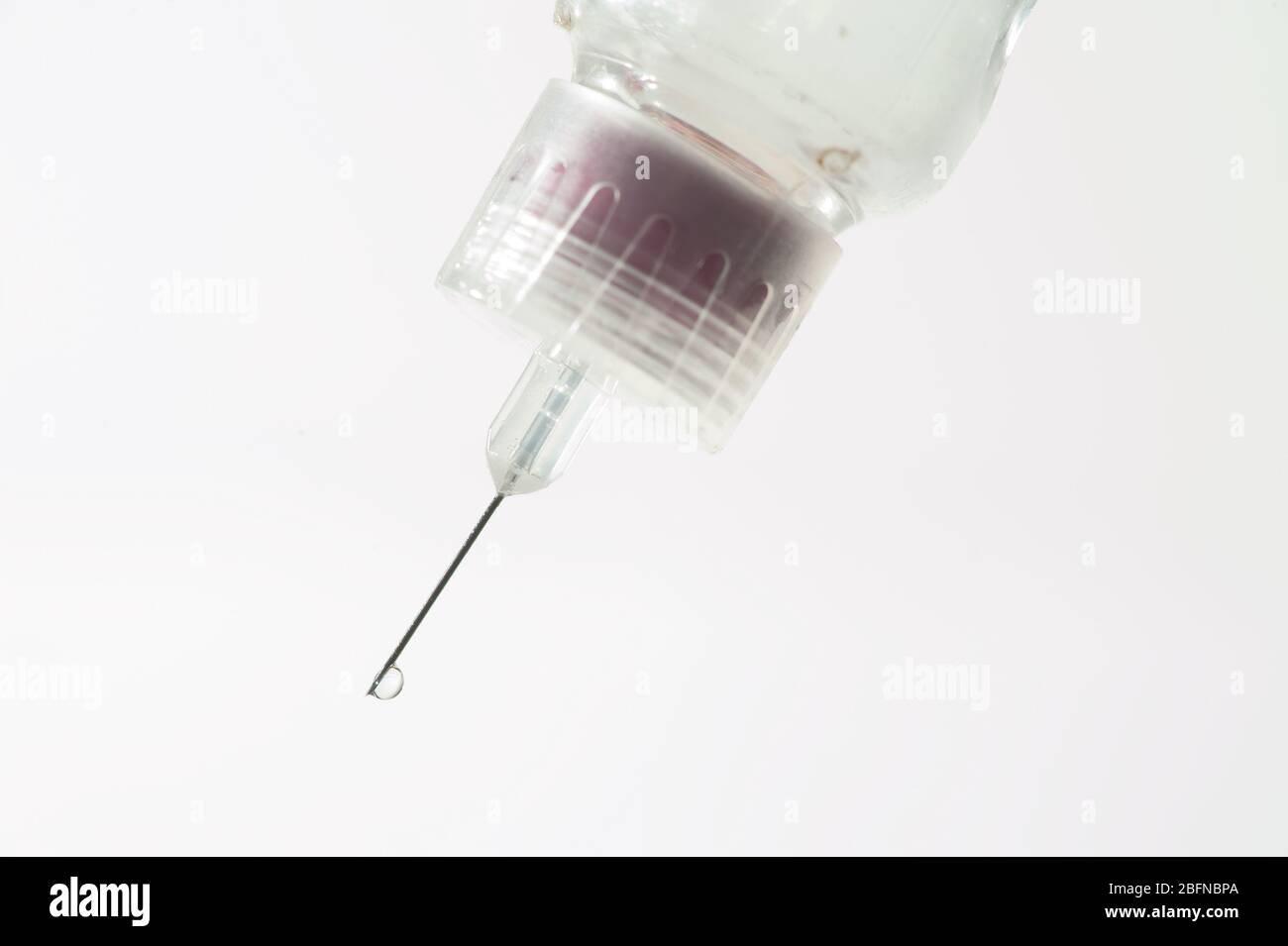 insulin injection dripping from the needle in a syringe on white ...