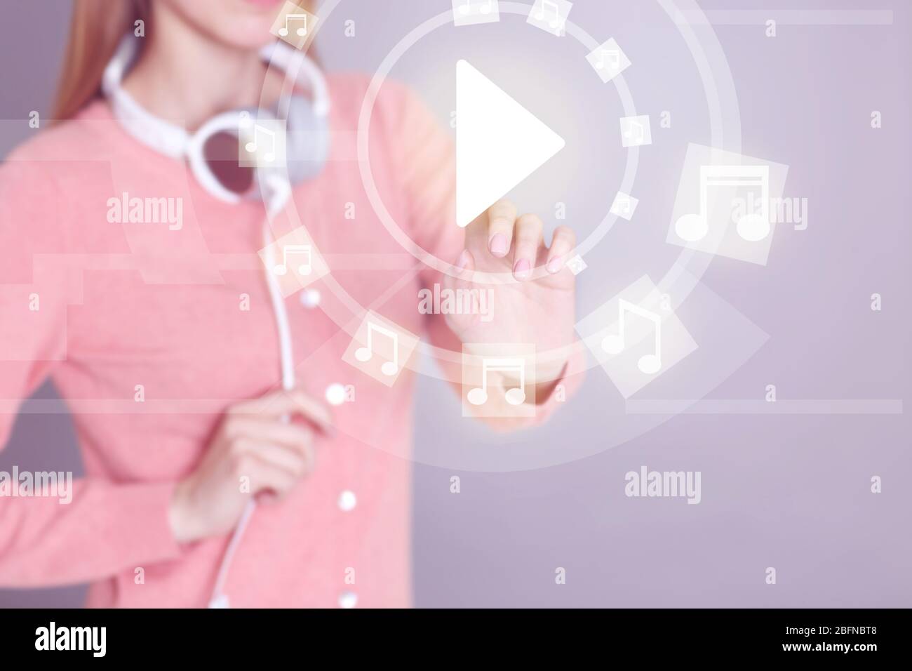 Woman pushing PLAY button on virtual screen to launch music player ...
