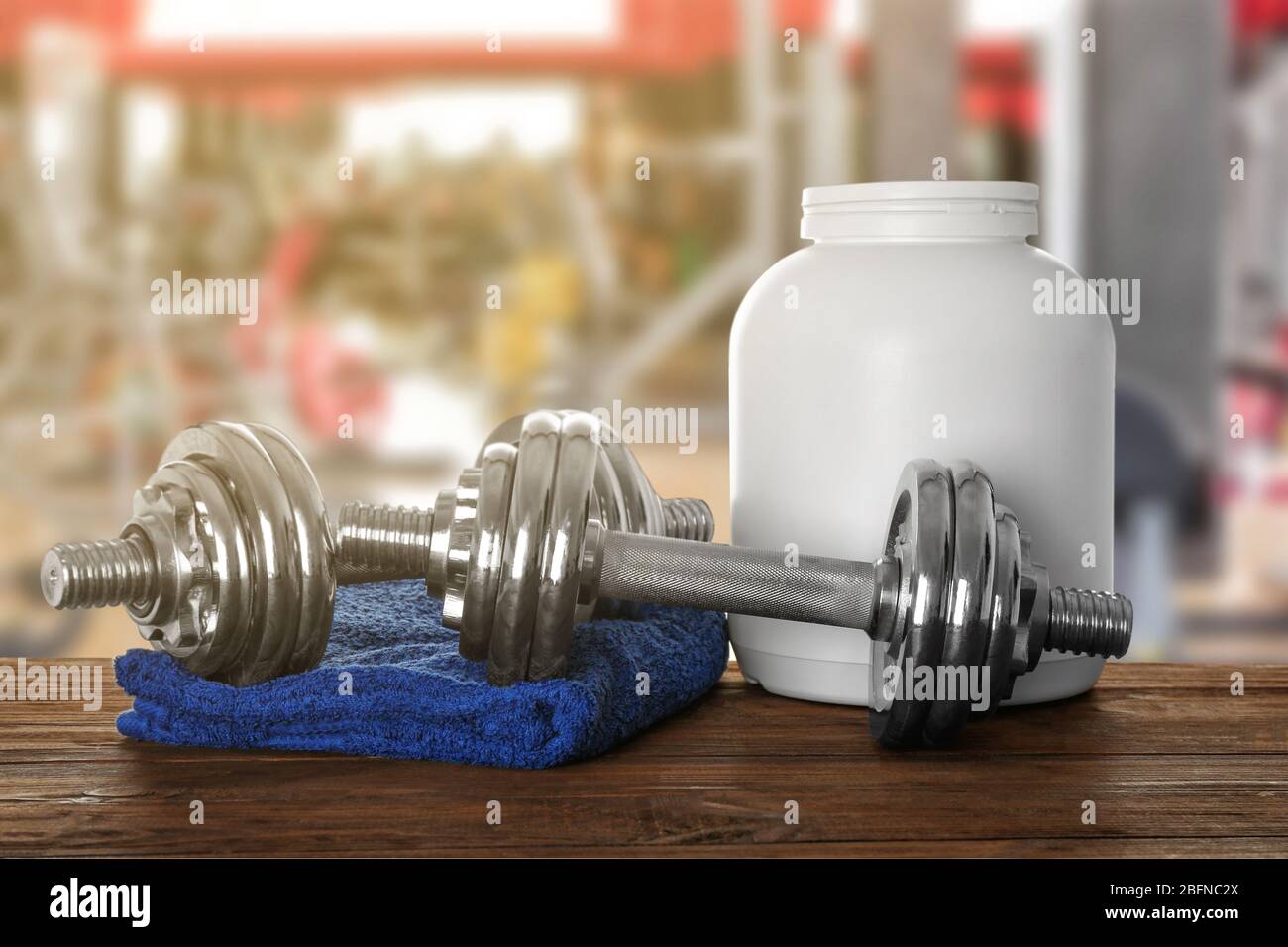 Sport stuff on table against blurred gym interior background Stock ...