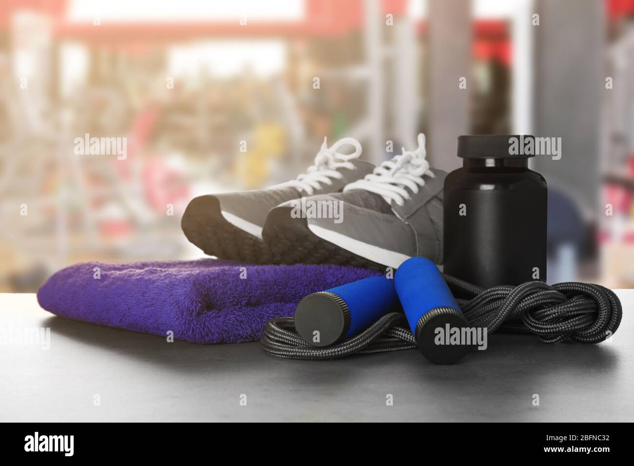 Sport stuff on table against blurred gym interior background Stock ...
