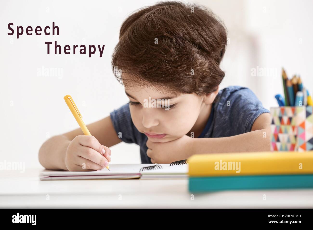 Little boy studying at home. Text SPEECH THERAPY on background Stock ...