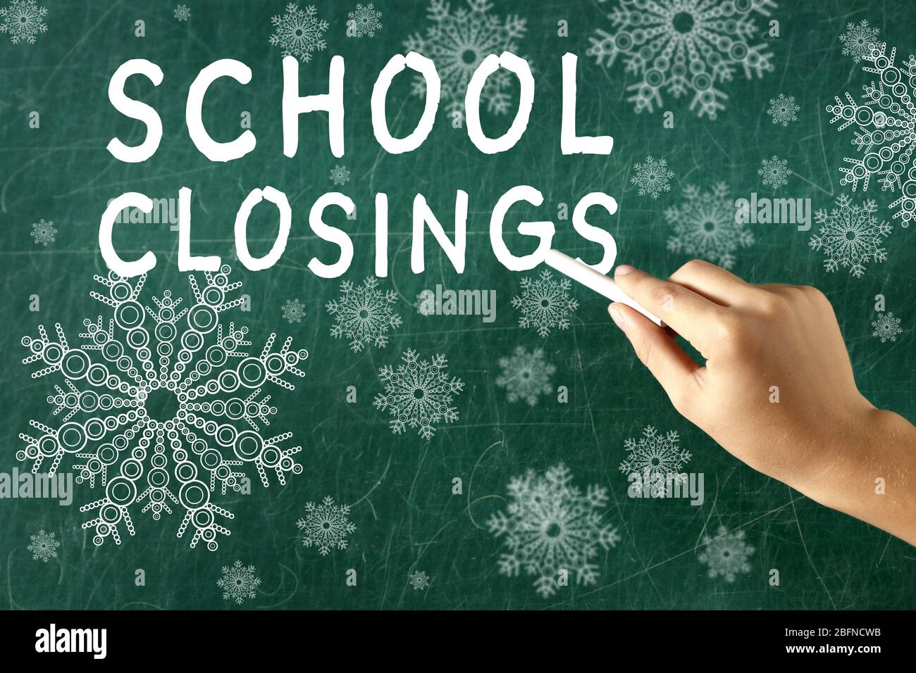 Text SCHOOL CLOSINGS and female hand with piece of chalk on blackboard ...