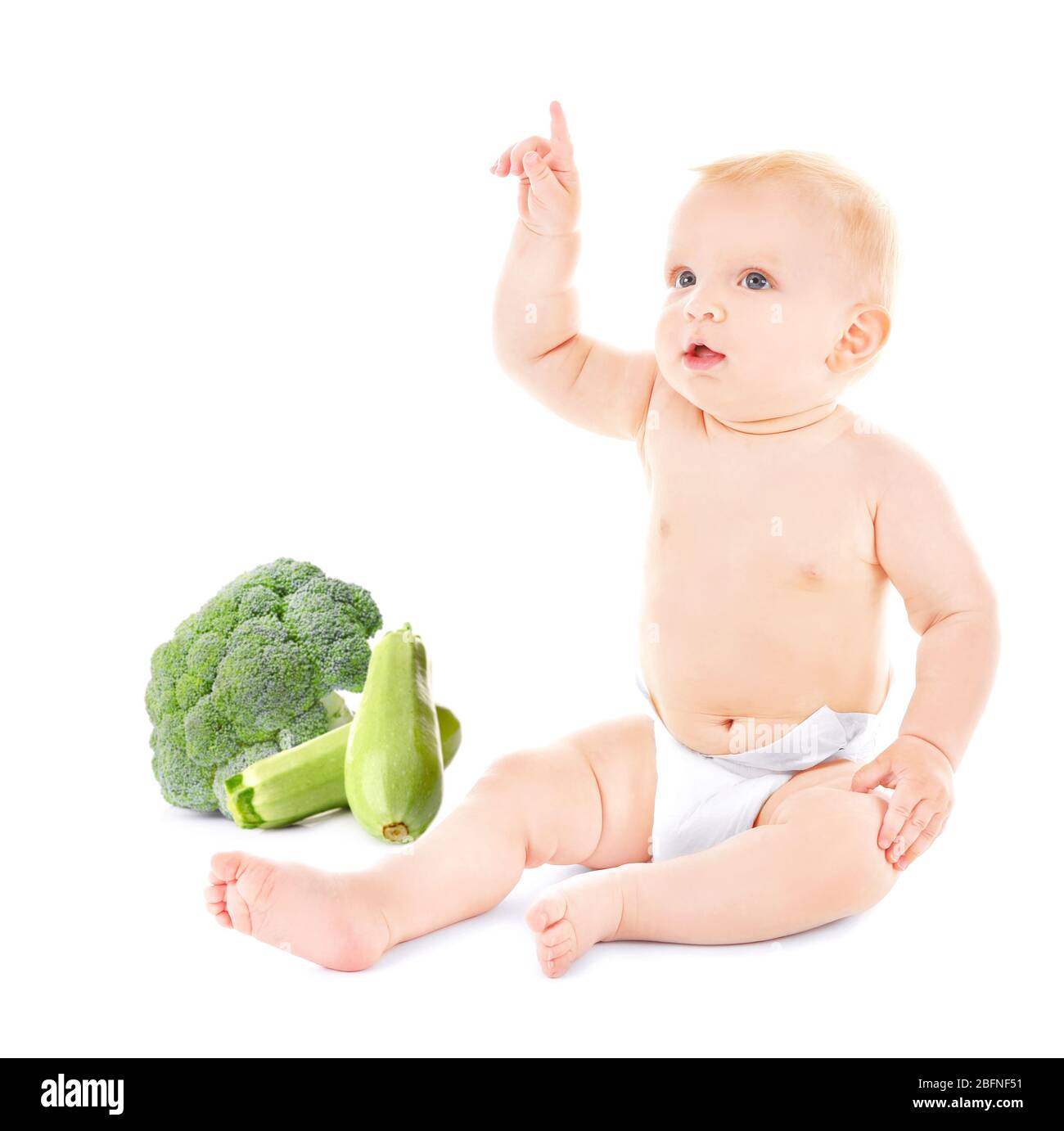 Cute baby with vegetables on white background Stock Photo - Alamy