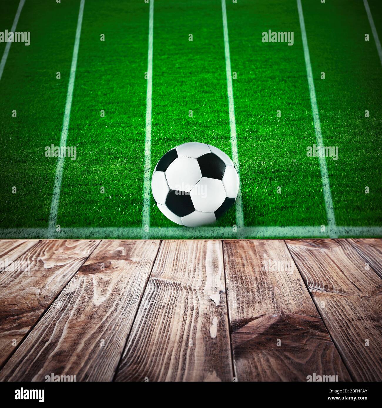 Wooden table against football field background Stock Photo - Alamy