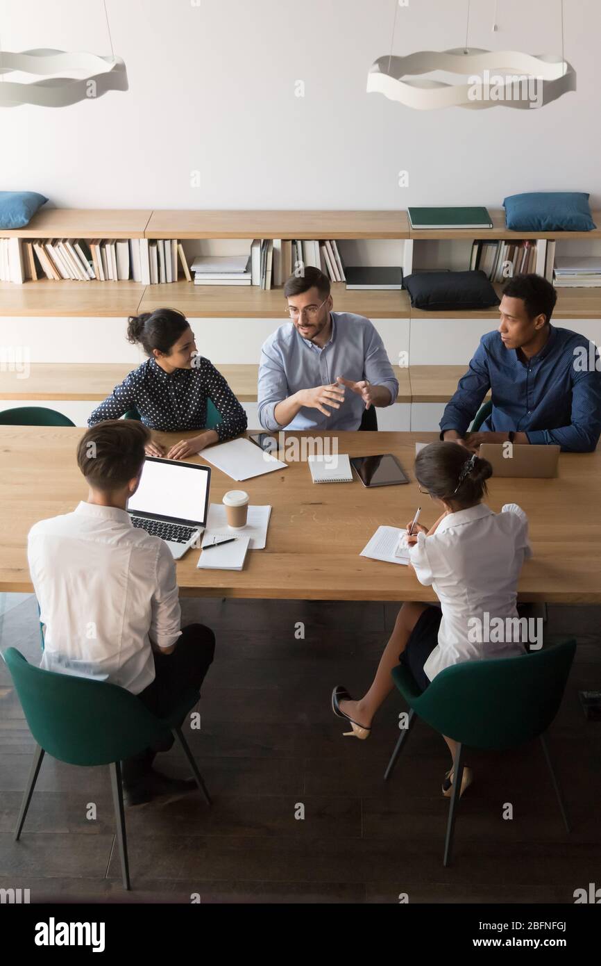 Vertical above view diverse business people negotiating in boardroom ...
