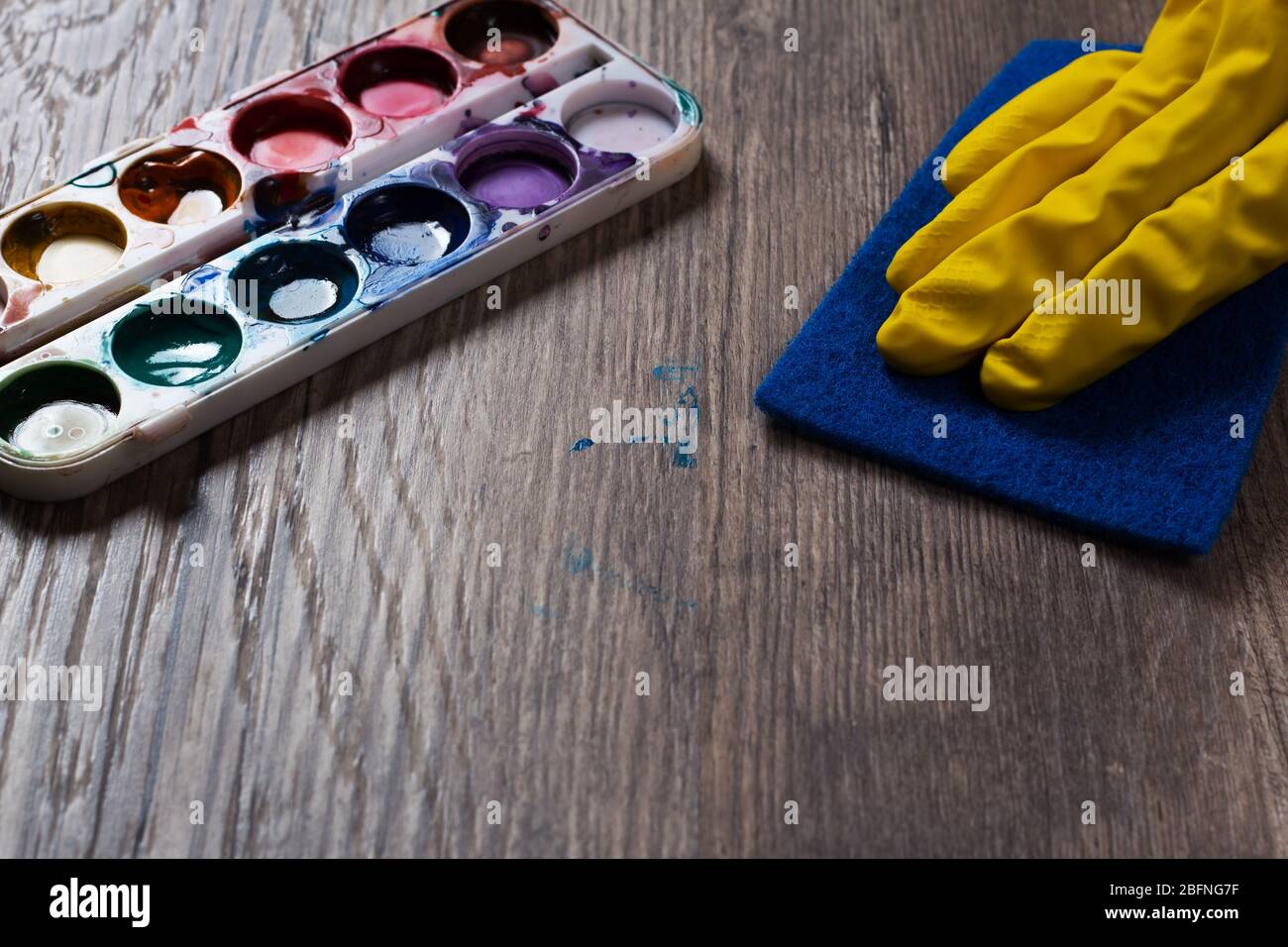 Woman cleans the table stained with paint. A stain from the paint ...