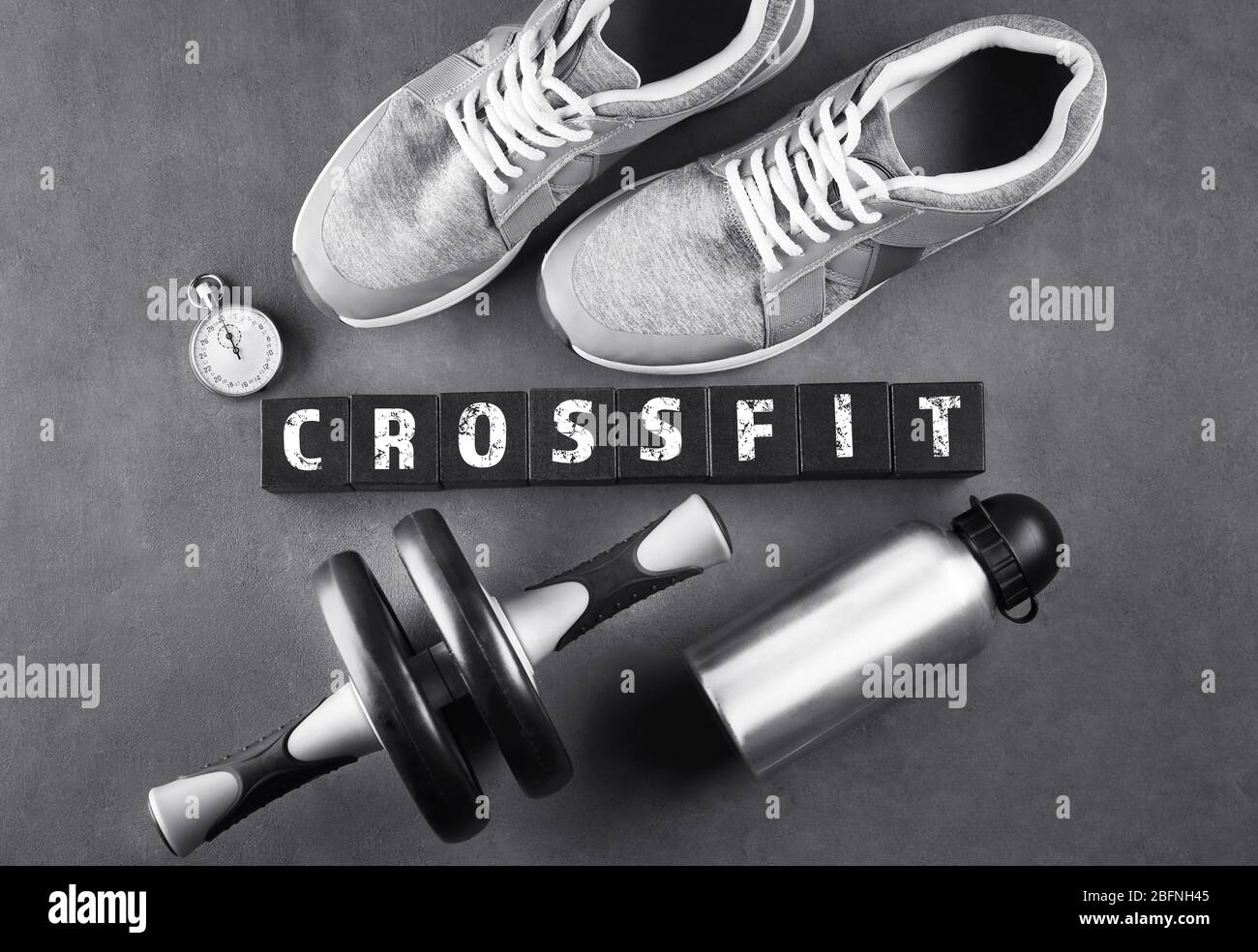 Sport concept. Word CROSSFIT of cubes and training equipment on gray ...
