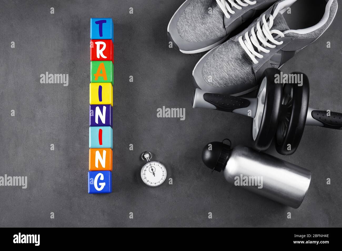 Sport concept. Word TRAINING of colorful cubes and equipment on gray ...