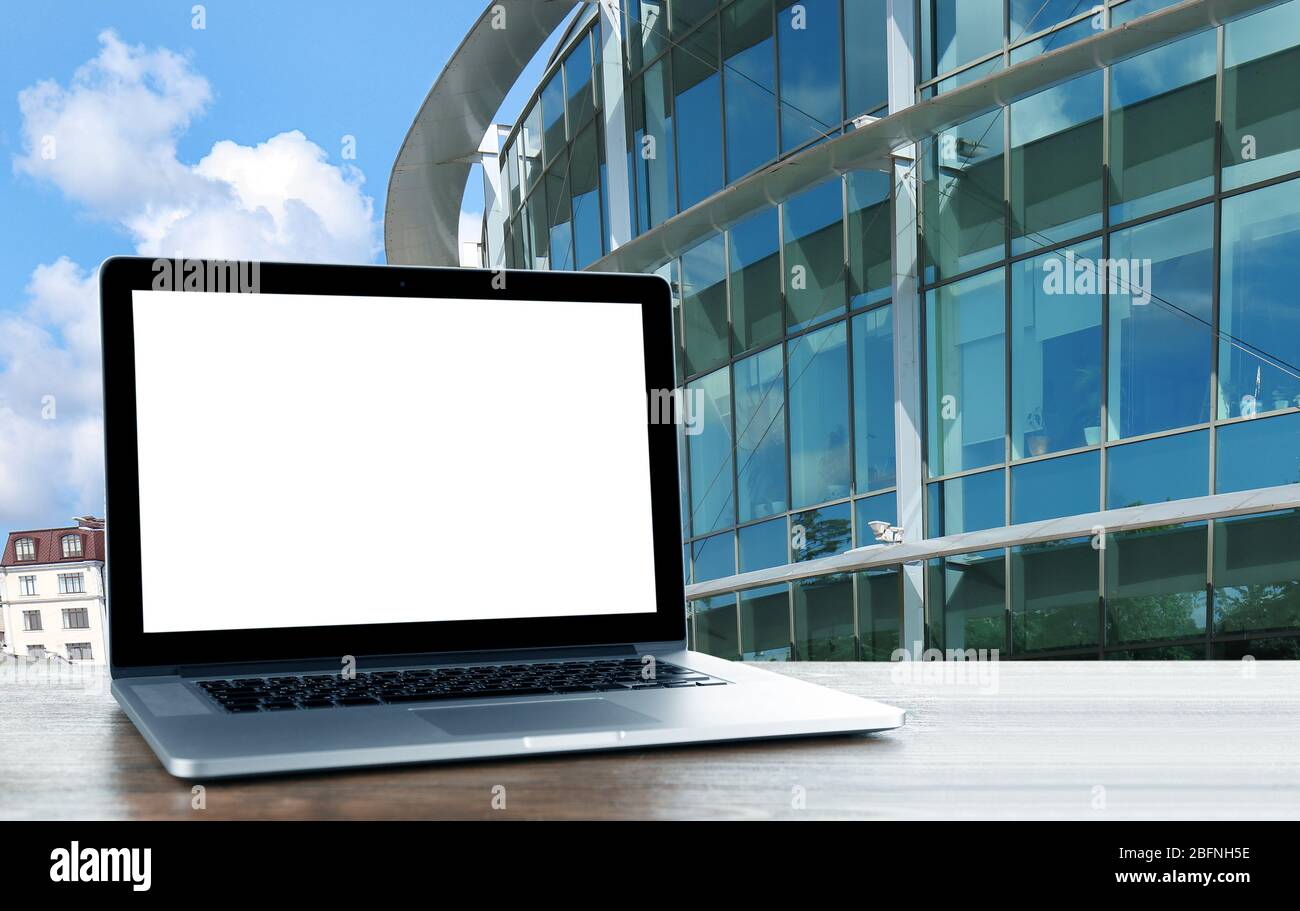 Modern technology concept. Laptop on table and cityscape view through ...