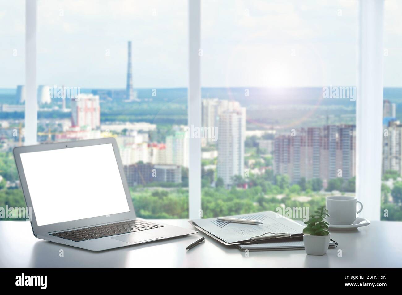 Modern technology concept. Laptop on table and cityscape view through ...