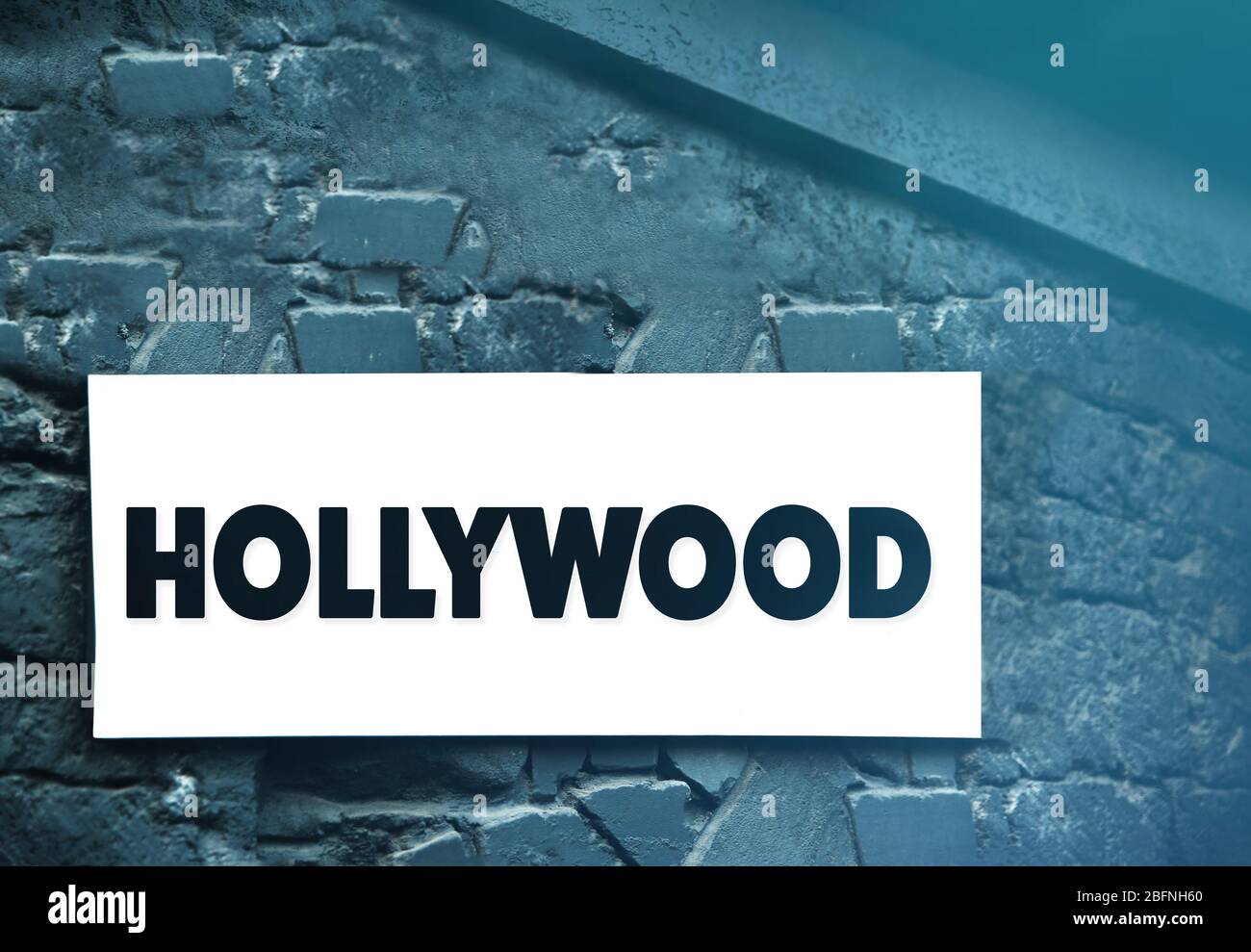 Street sign with word HOLLYWOOD on brick wall background Stock Photo ...