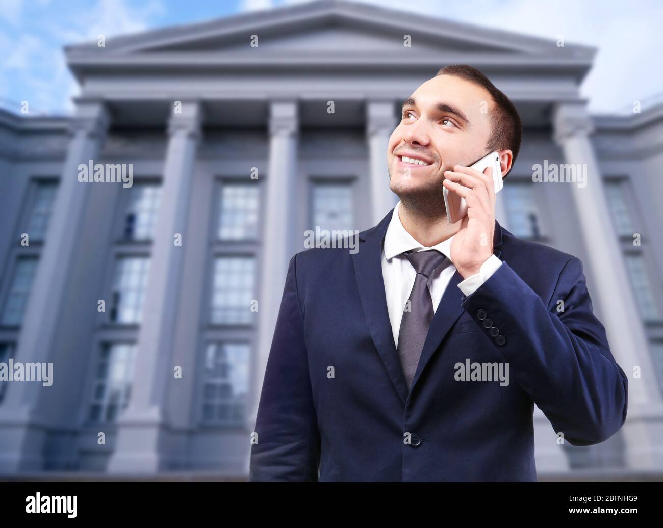Law and justice concept. Young man talking on phone against courthouse ...