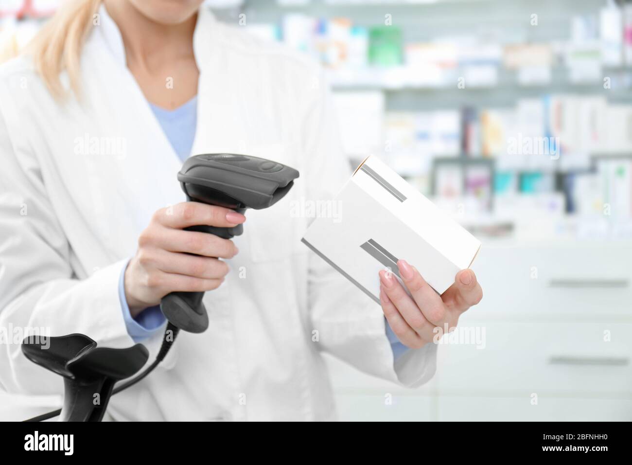 Female cashier scanning barcode on package at shop Stock Photo - Alamy