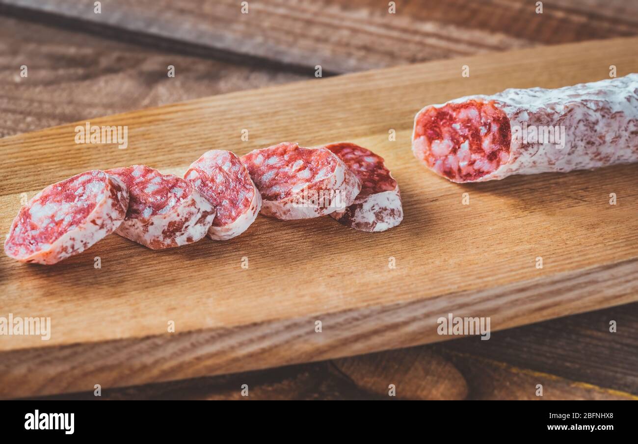 Fuet - Catalan dry cured sausage on the wooden board Stock Photo - Alamy