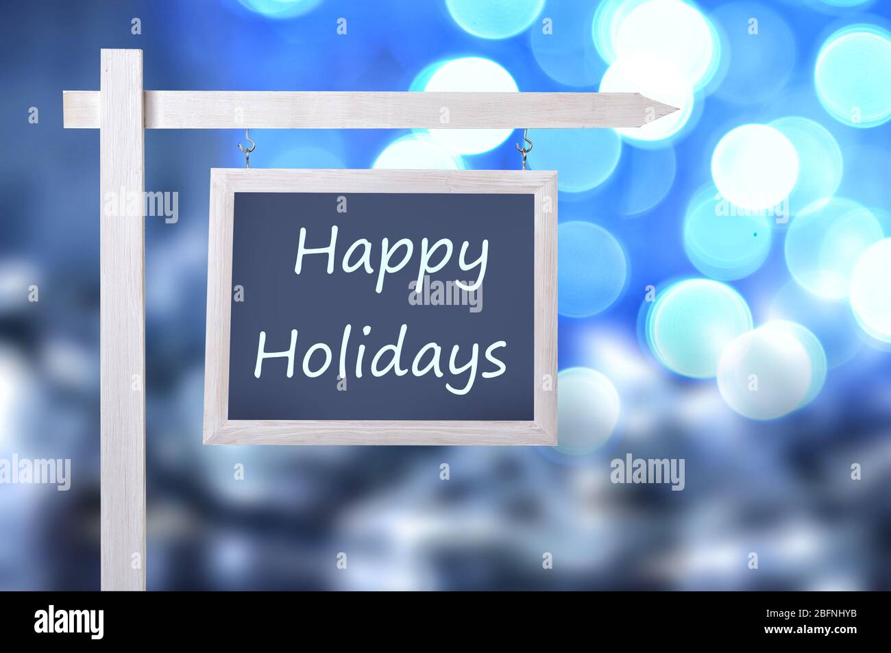 Signboard with text HAPPY HOLIDAYS on blurred lights background Stock ...