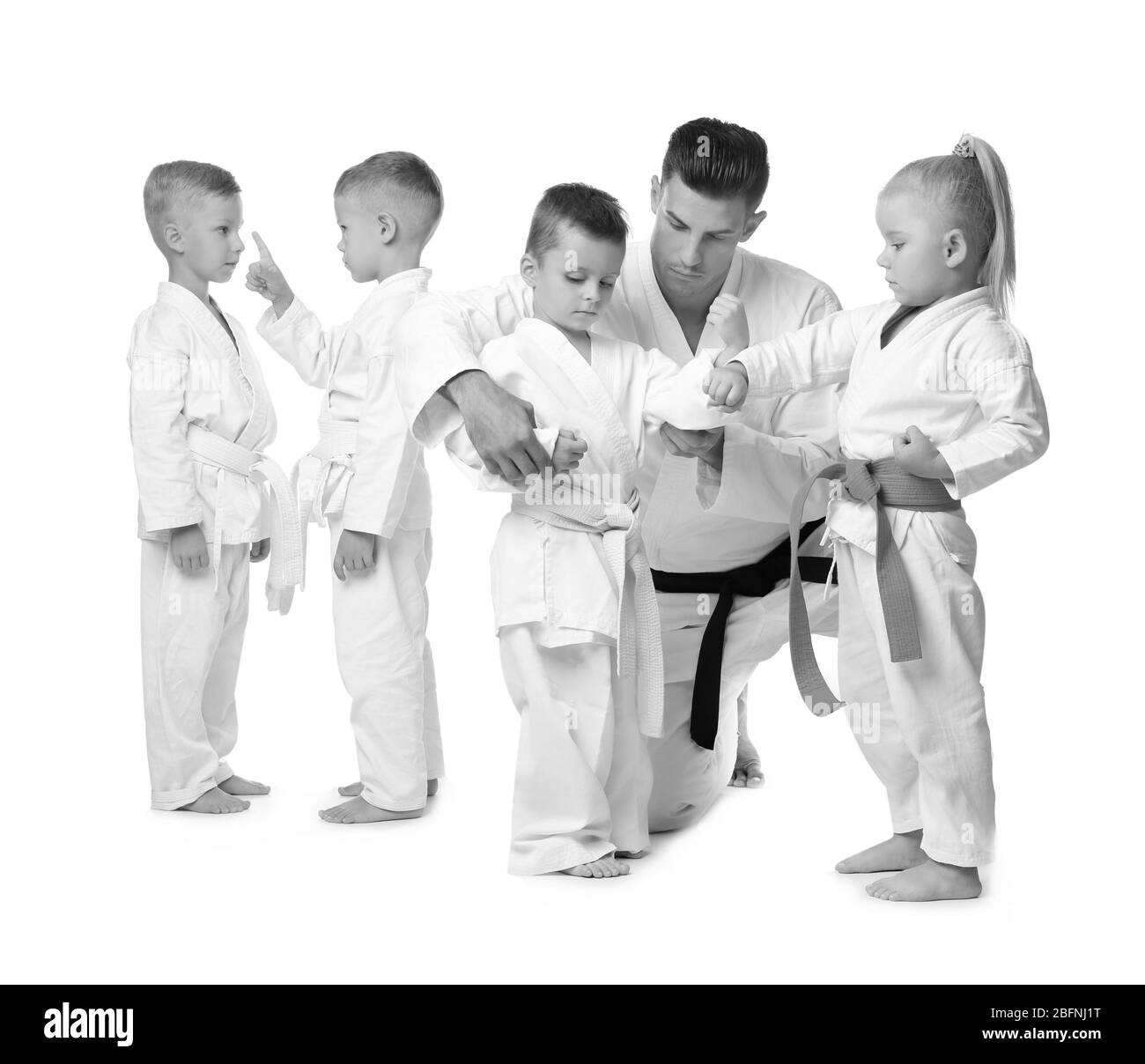 Little children with teacher practising karate on white background ...