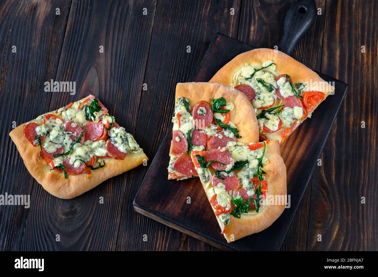 Spanish coca with blue cheese, fuet and arugula Stock Photo - Alamy
