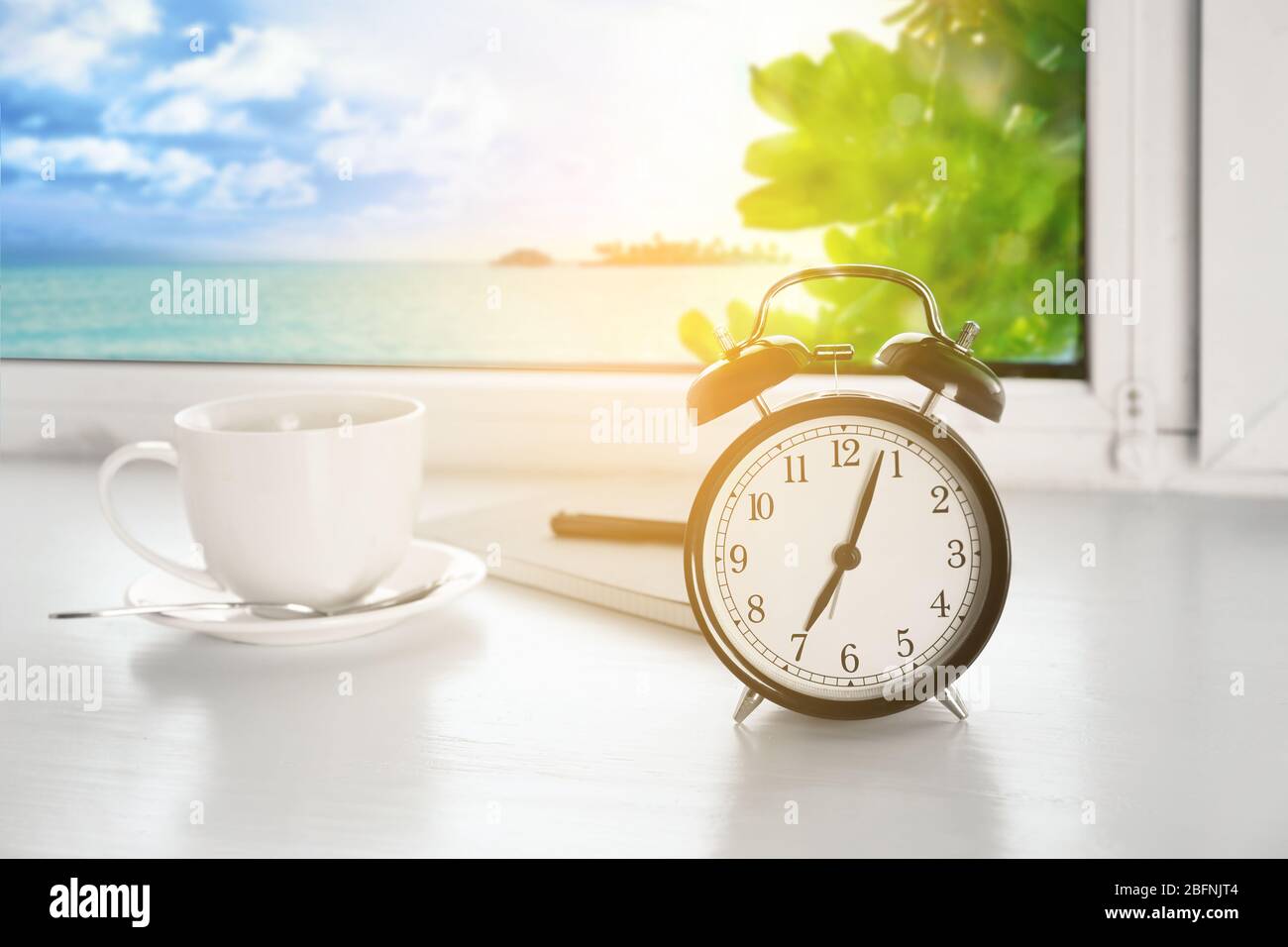Alarm clock on window sill in morning Stock Photo - Alamy
