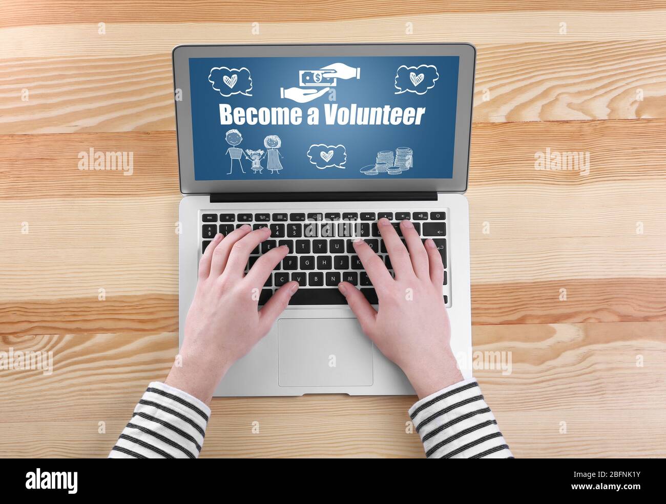 Woman using laptop with text BECOME A VOLUNTEER on screen at table ...