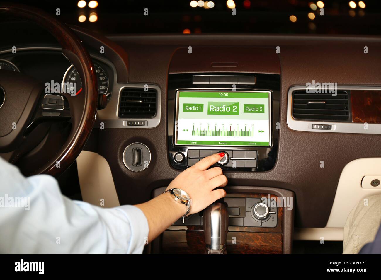 Woman listening to radio while driving car at night Stock Photo - Alamy