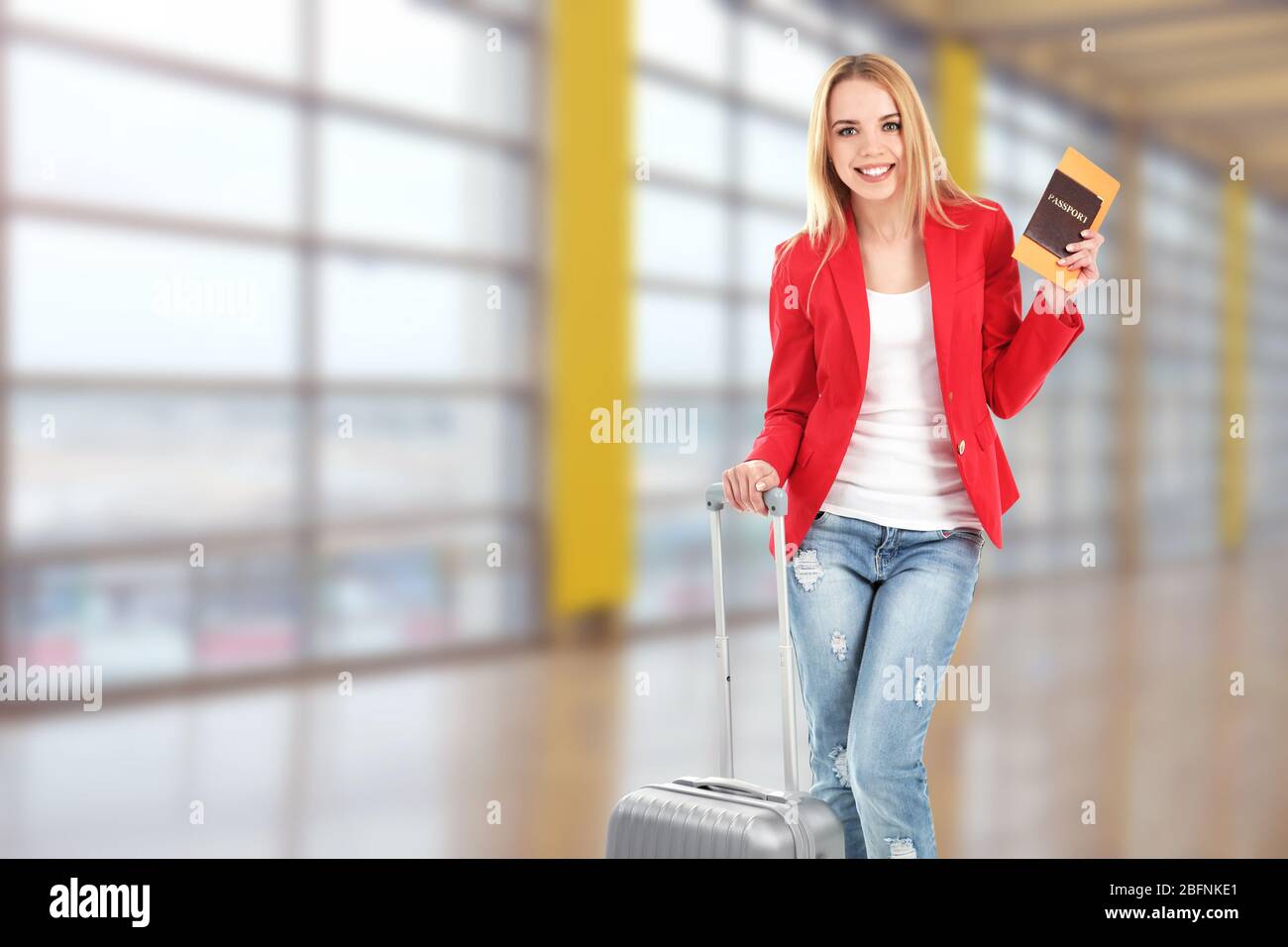 Young woman with passport and baggage at airport Stock Photo - Alamy