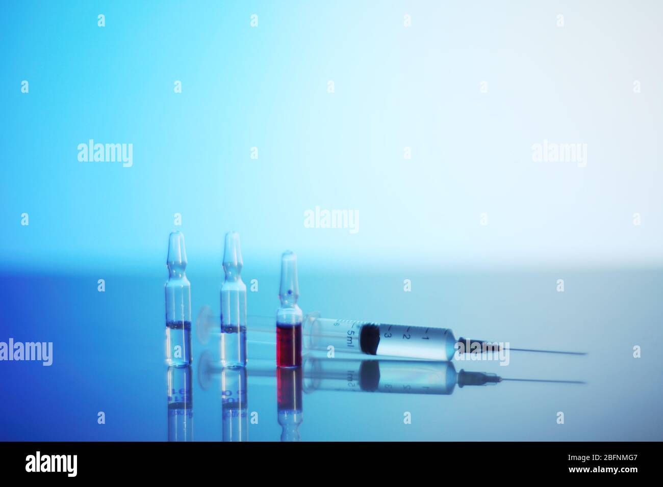 Syringe and ampoules on glowing blue reanimation light background Stock ...