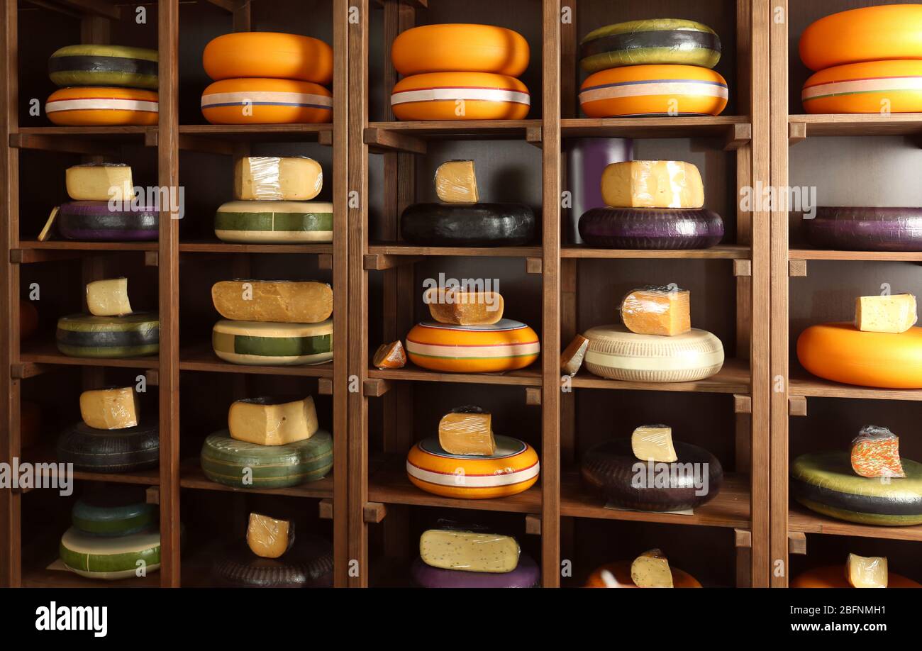 Wooden stand with different kinds of delicious cheese in shop Stock ...
