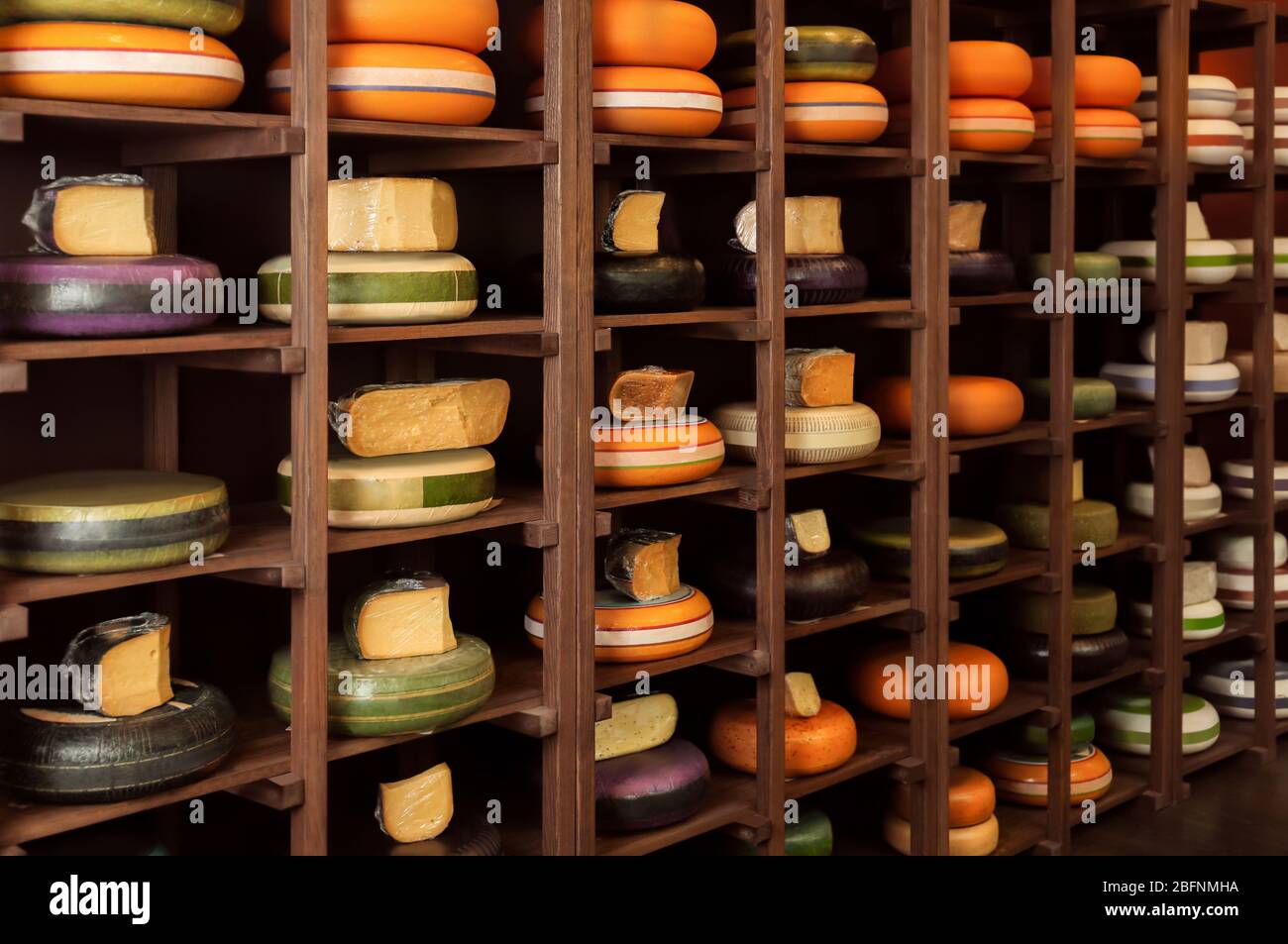 Wooden stand with different kinds of delicious cheese in shop Stock ...