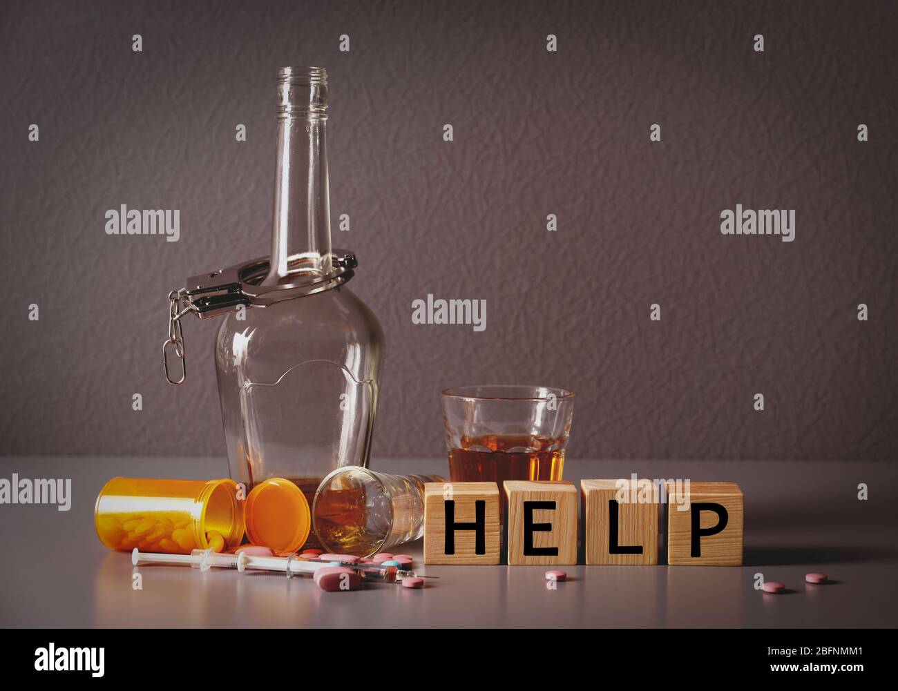 Strong drink, drugs, handcuffs and cubes with word HELP on table ...