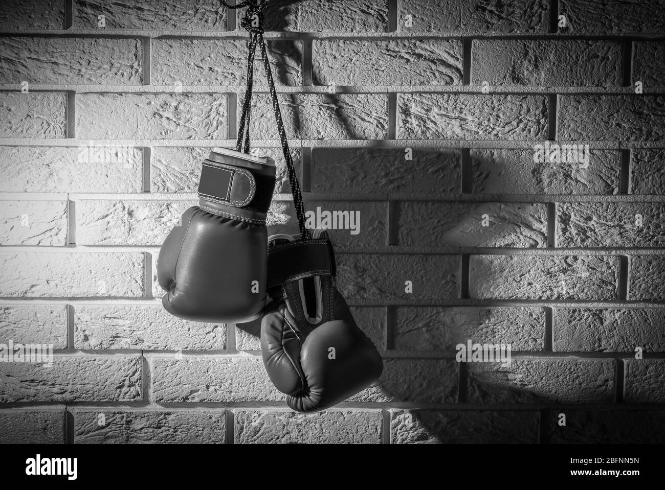 Pair of boxing gloves hanging on brick wall Stock Photo - Alamy