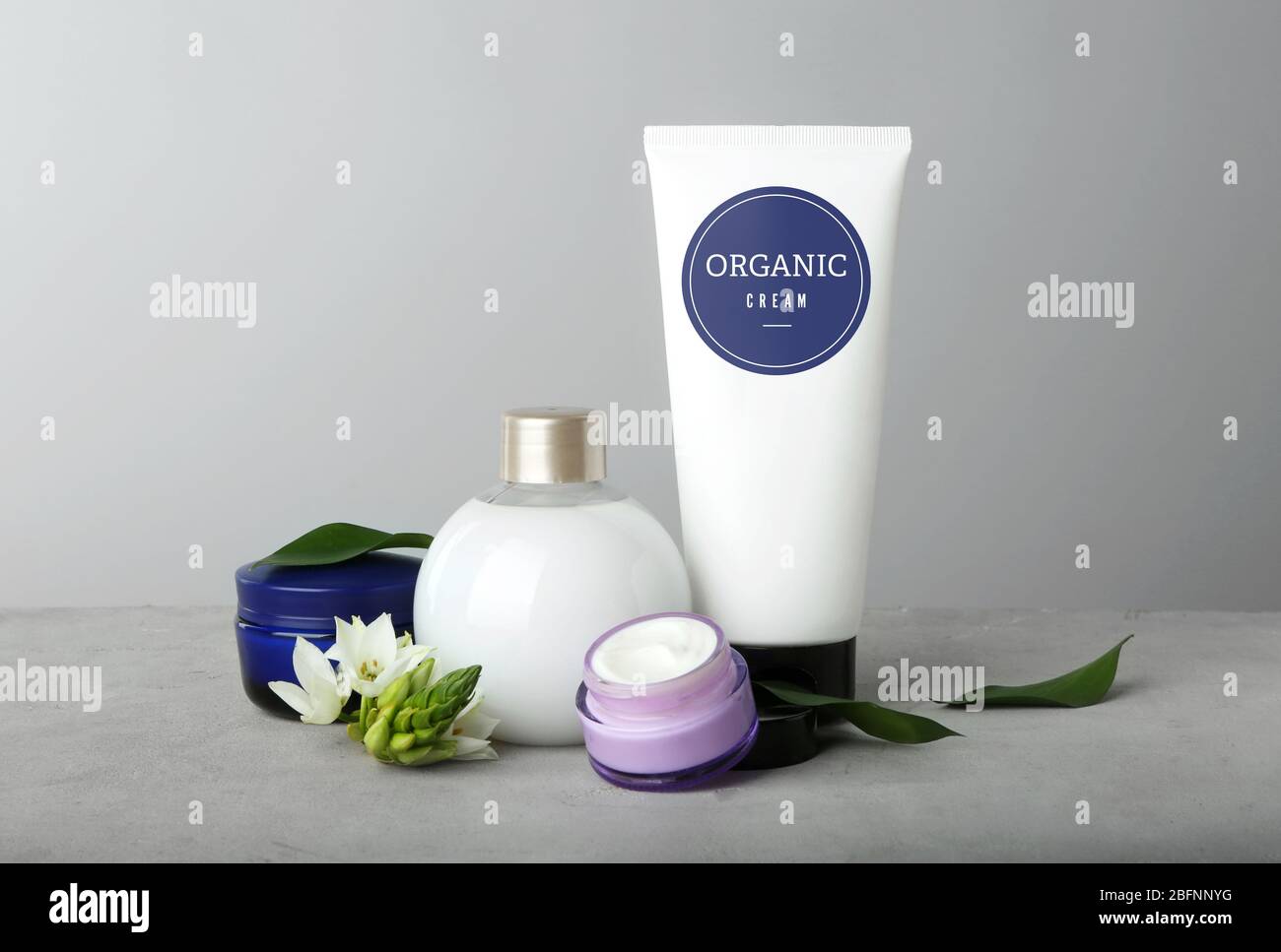 Body cream set with natural extracts on table against grey background ...