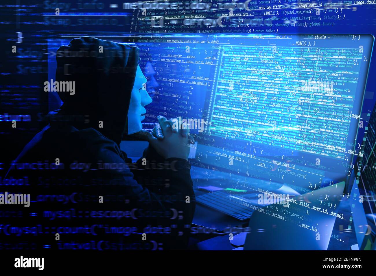Hacker in mask using computer in darkness. Concept of cyber attack and ...