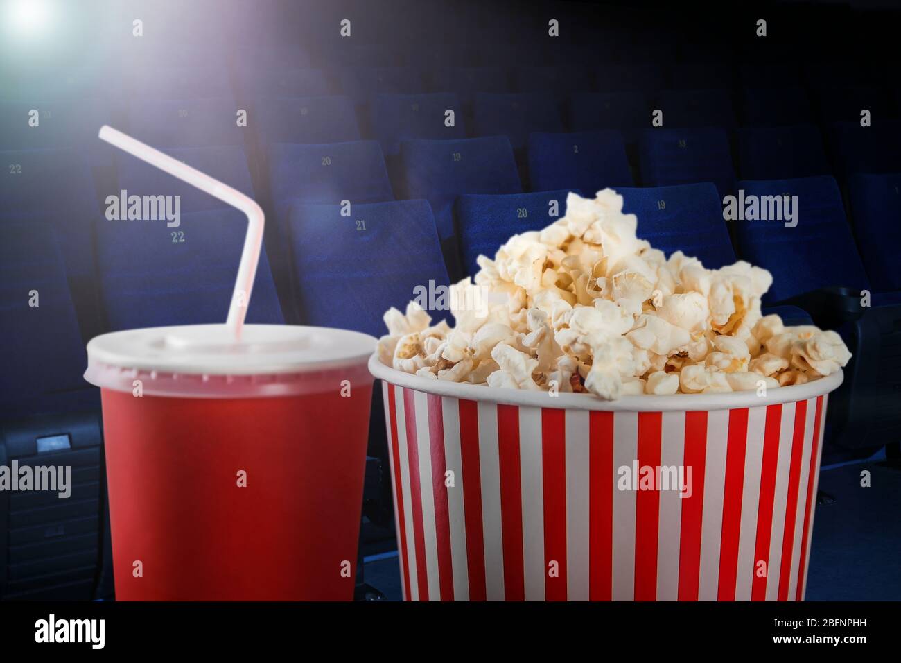 Tasty popcorn and cup of drink in cinema Stock Photo - Alamy