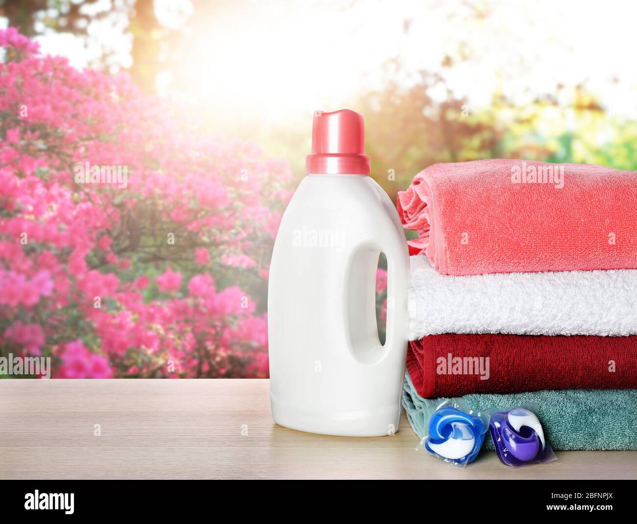 Folded towels and laundry detergents on table outdoors Stock Photo - Alamy