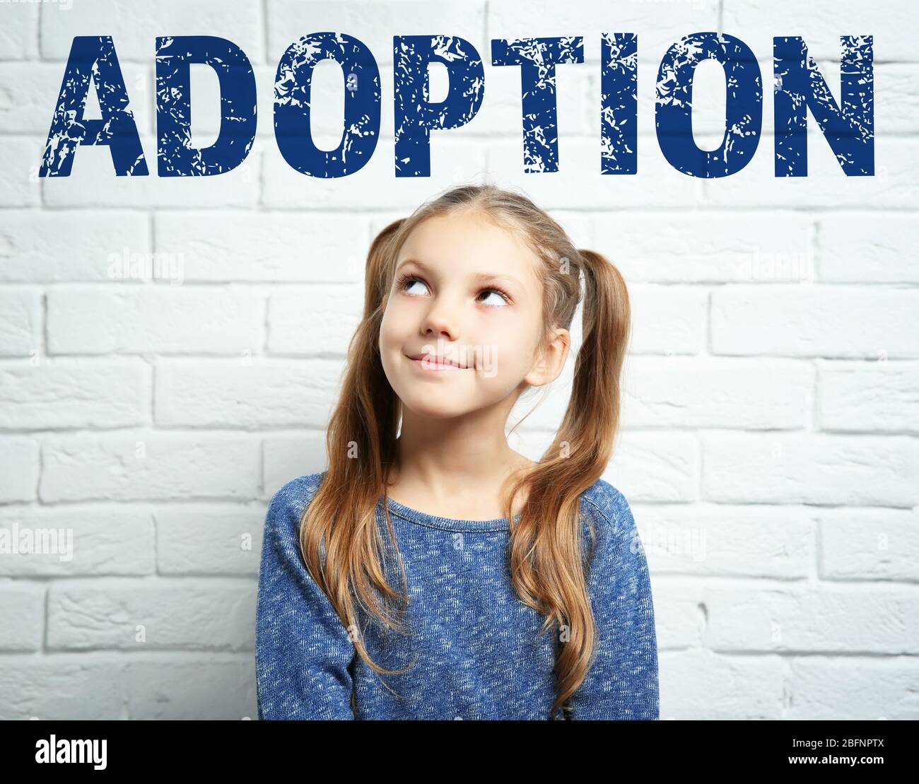 Adoption concept. Happy little girl on brick wall background Stock ...