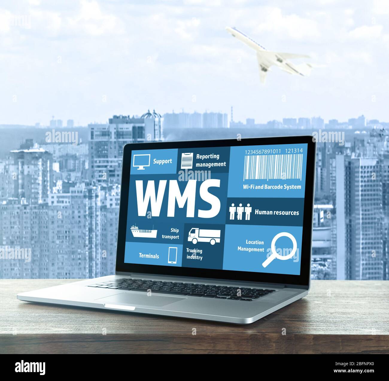 Warehouse management system concept. Laptop on table against cityscape ...