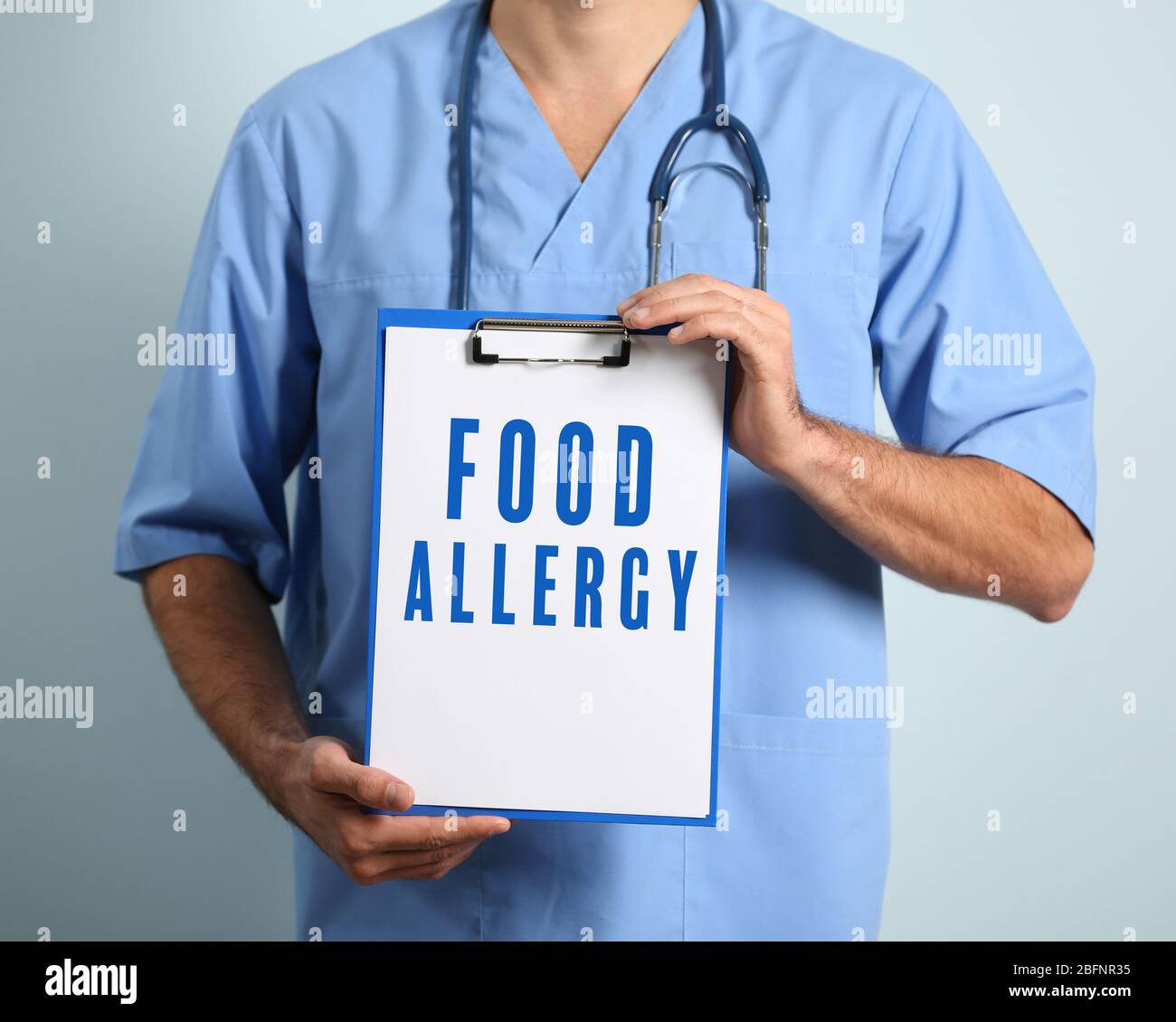Health care concept. Doctor holding clipboard with text FOOD ALLERGY on ...