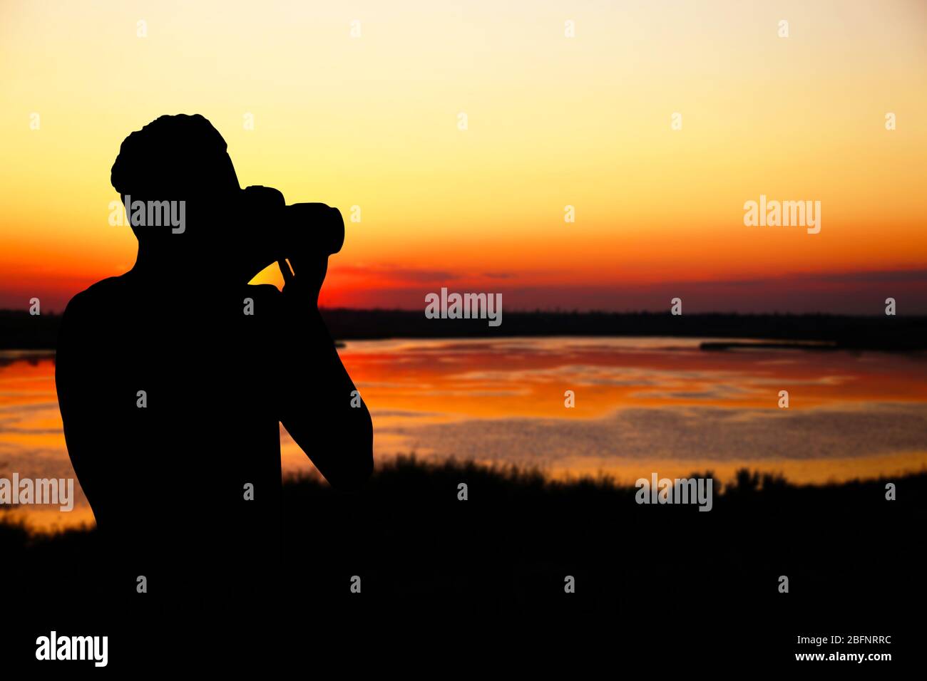 Silhouette of professional photographer taking photo of beautiful ...