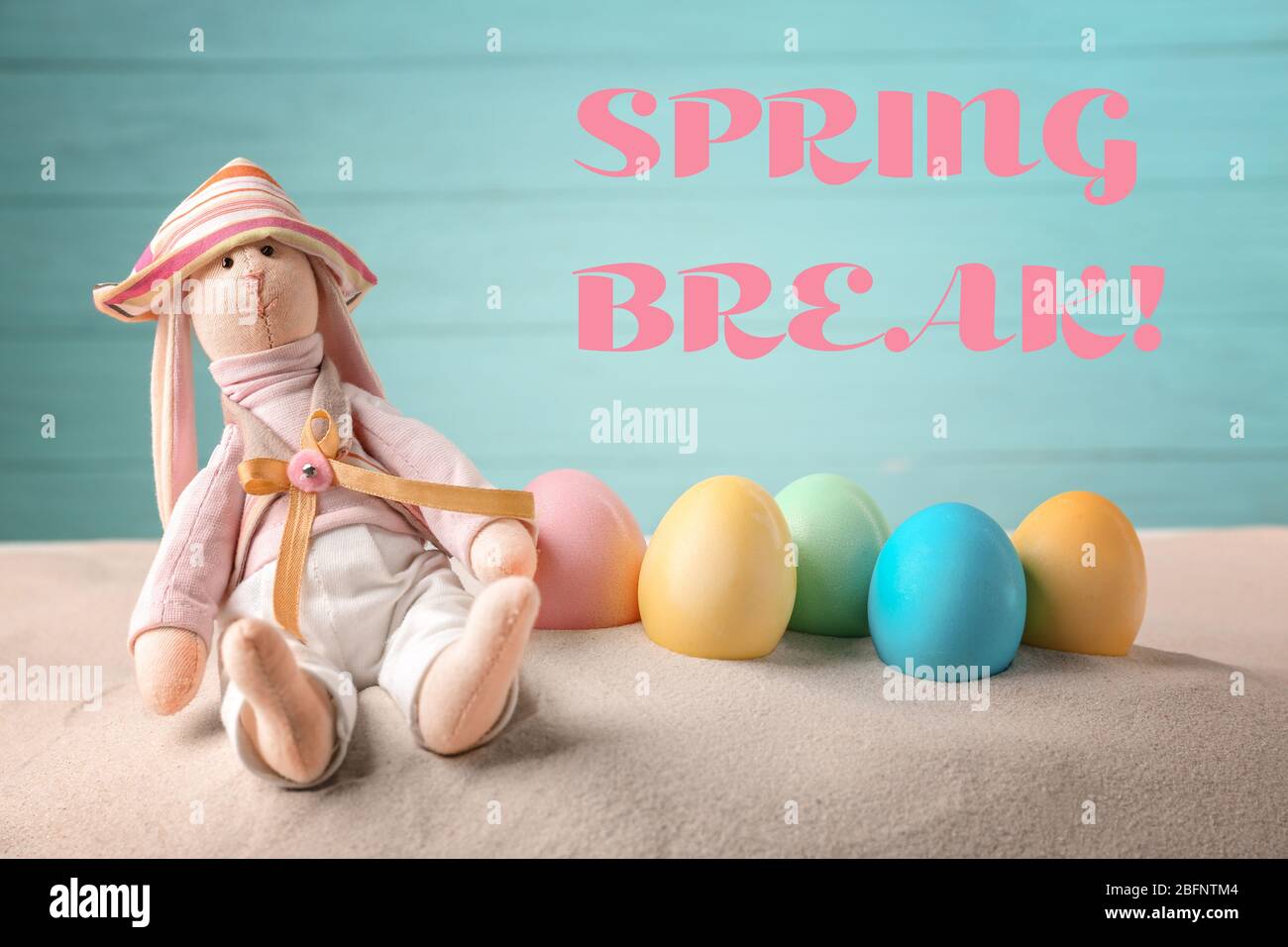 Spring break concept. Colorful Easter eggs and toy bunny on sand Stock ...