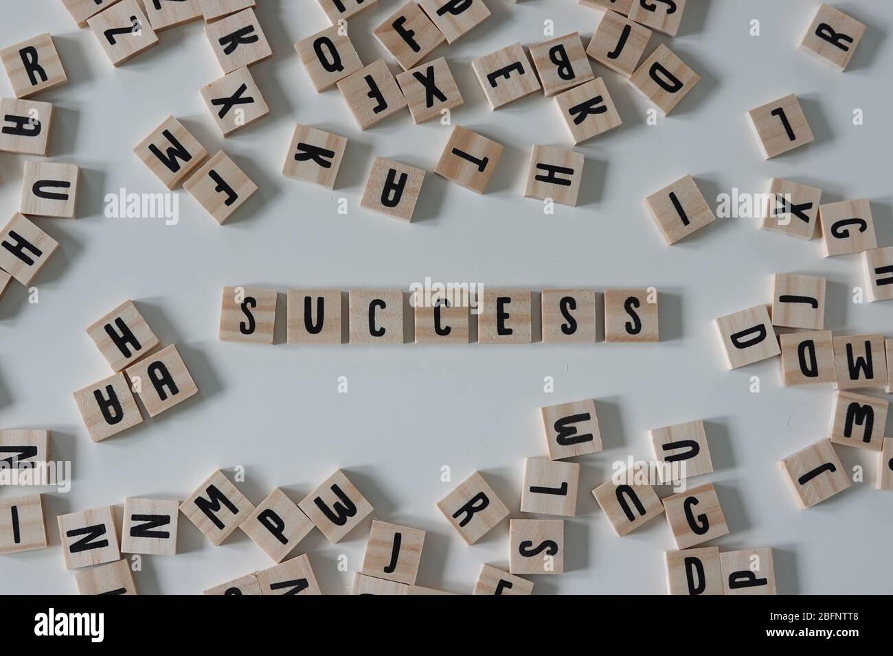 Success written in wooden letter tiles surrounded by random letters on ...