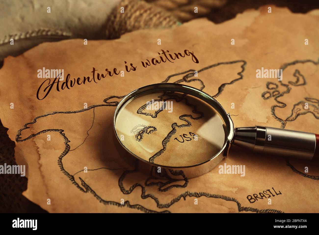 Text ADVENTURE IS WAITING and magnifier on old map Stock Photo - Alamy