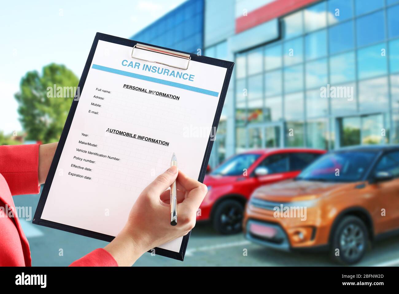 Woman filling in car insurance form on auto center background Stock ...