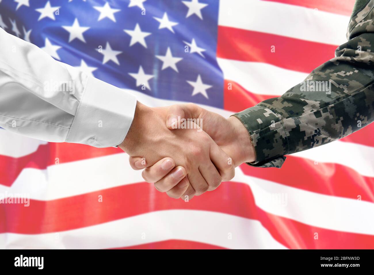 Soldier and civilian shaking hands on USA flag background Stock Photo ...