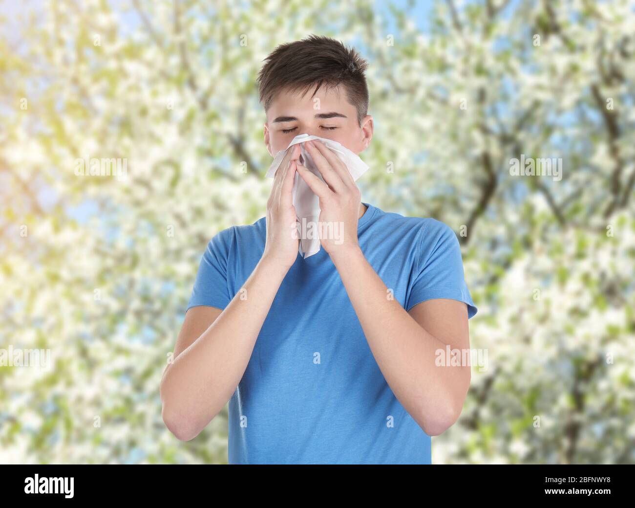 Seasonal allergy. Young man with tissue outdoor Stock Photo - Alamy
