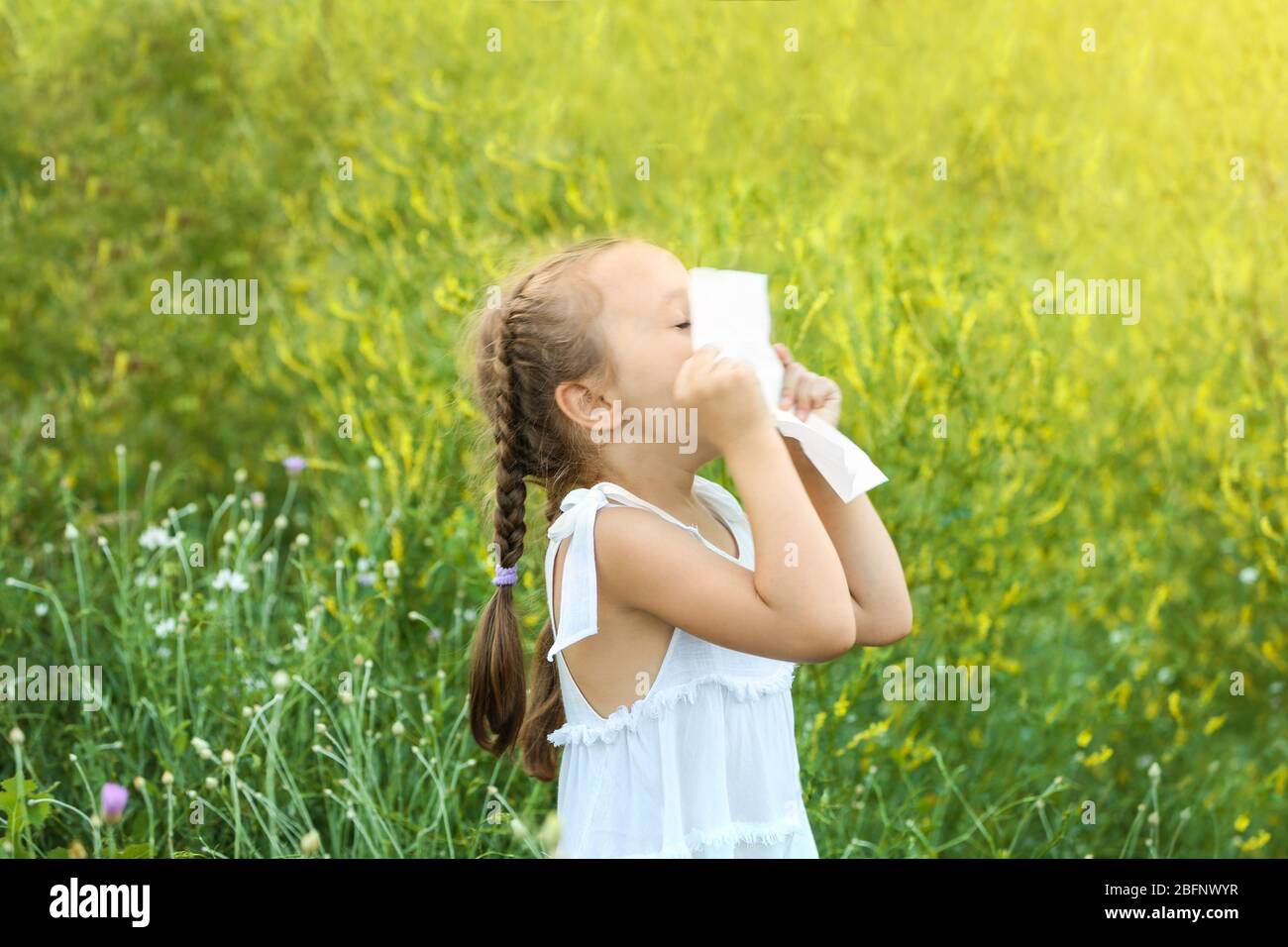 Seasonal allergy. Little girl with tissue outdoor Stock Photo - Alamy