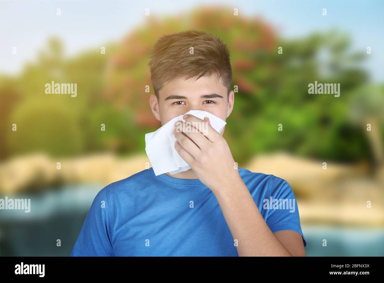 Seasonal allergy. Young man with tissue outdoor Stock Photo - Alamy